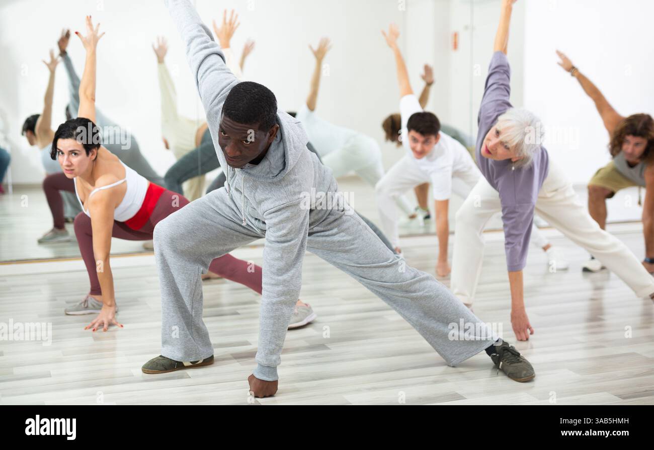 Group of active people performing a stretching exercise Stock Photo - Alamy