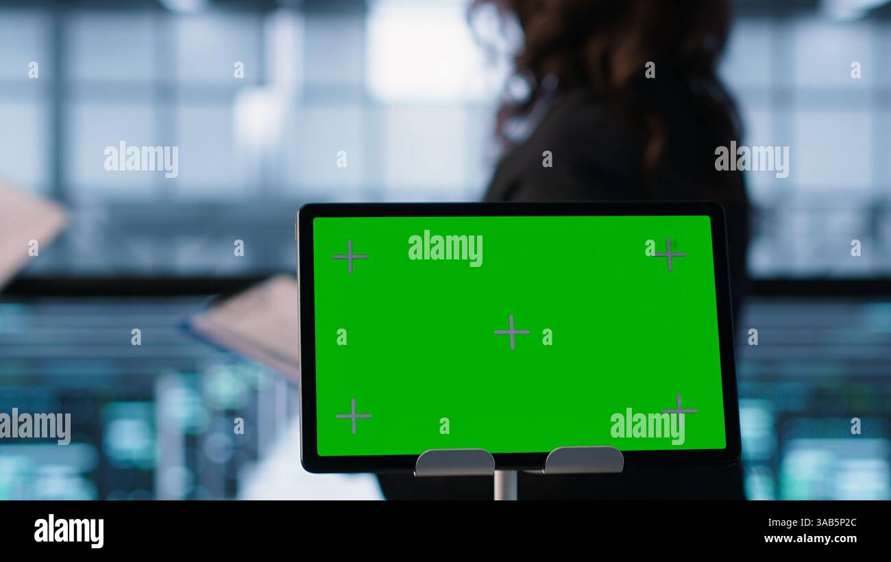 Close up of chroma key tablet next to server room data scientists conducting security audits ...
