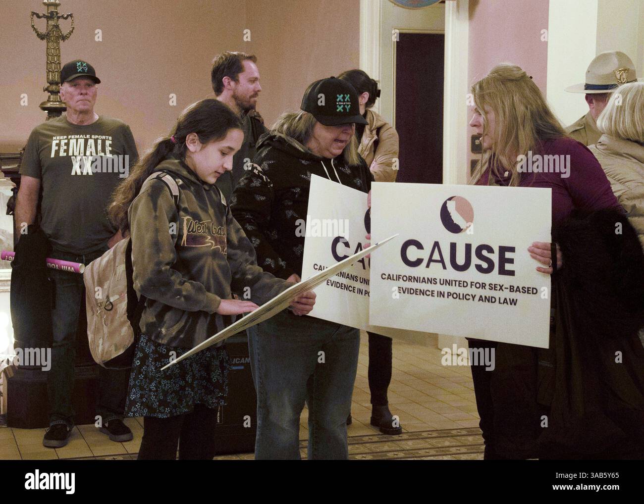 Supporters hold signs while they wait in line outside a hearing to ...