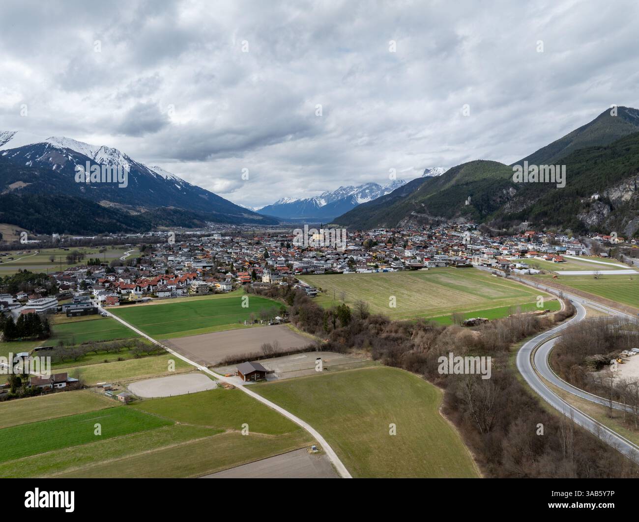 Small Town in Austrian Alps with Snow Capped Mountains and Green Fields ...