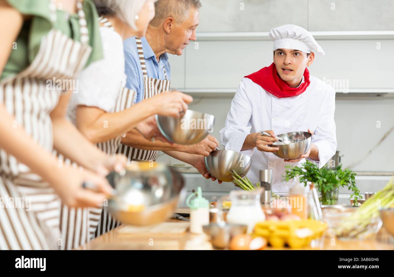 Young guy cook teaches to cook group of people Stock Photo - Alamy