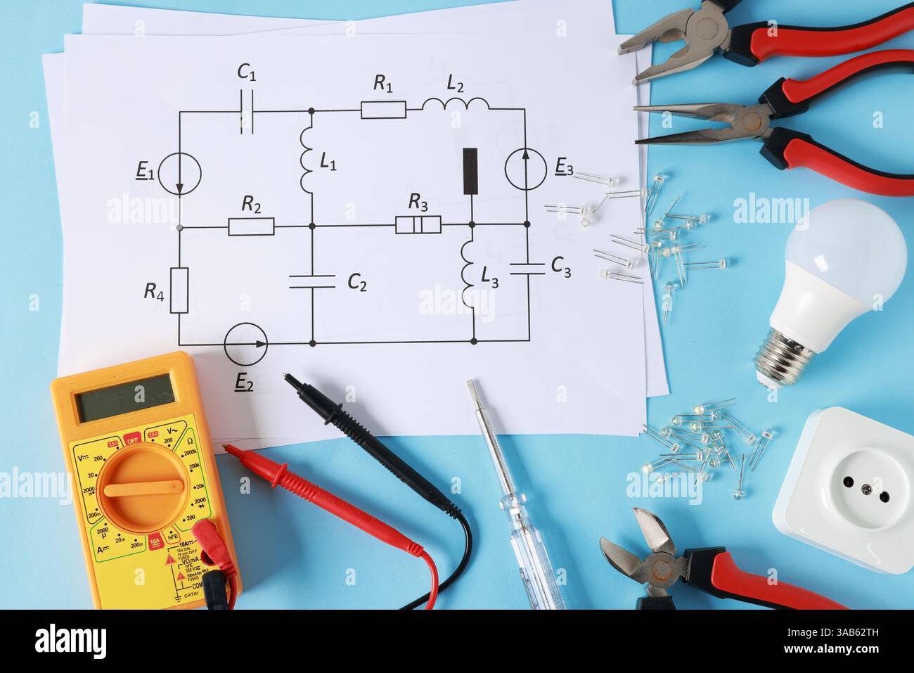 Different electrical tools and circuit diagram on light blue background ...