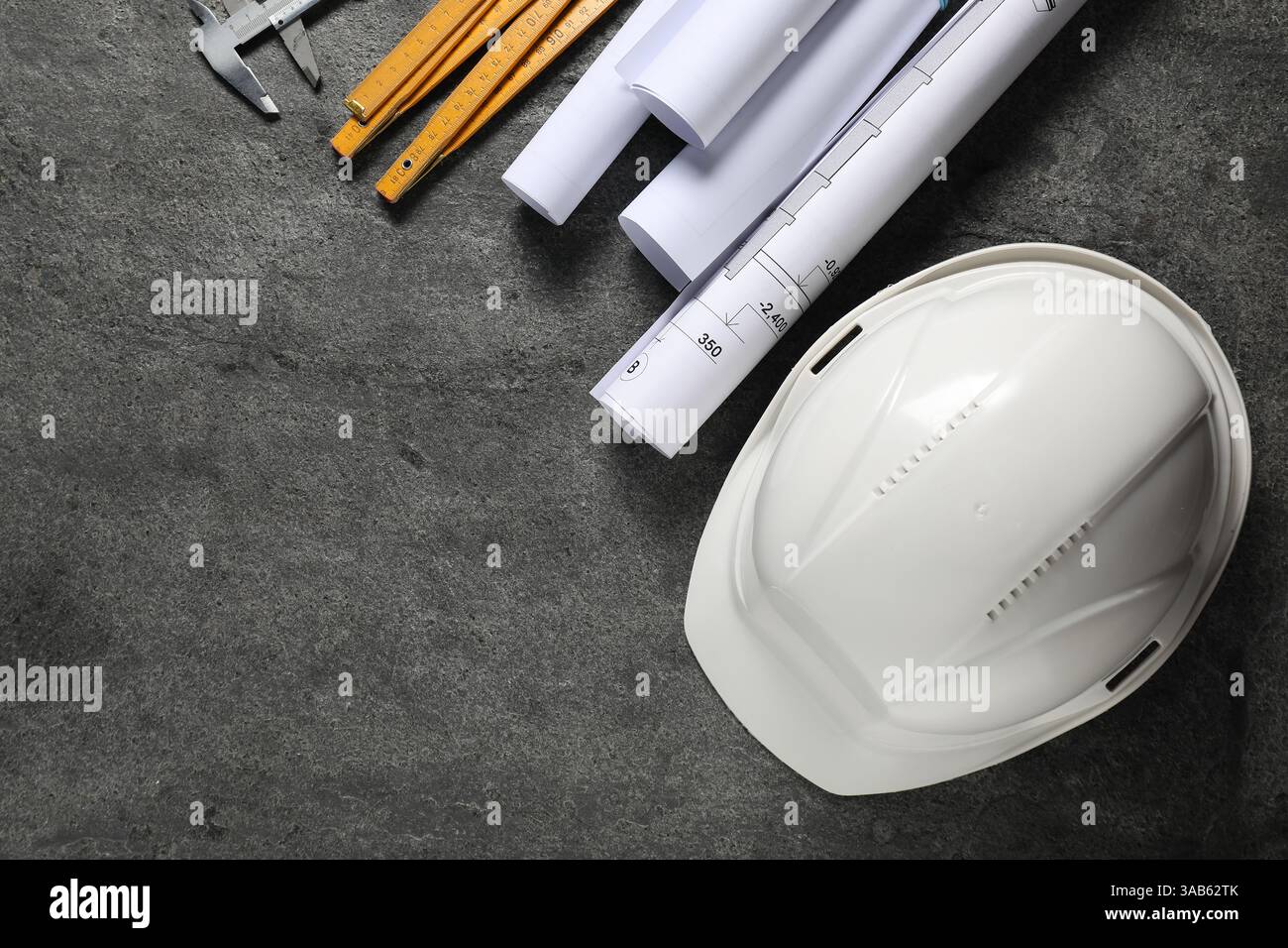 Hard hat, different engineering drawings, folding ruler and vernier ...