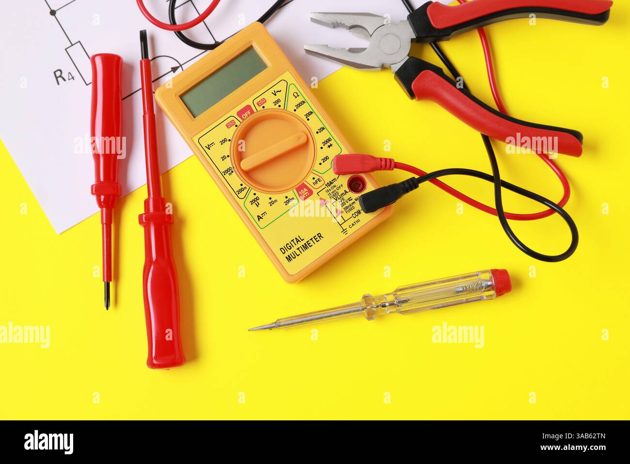 Different electrical tools and circuit diagram on yellow background ...