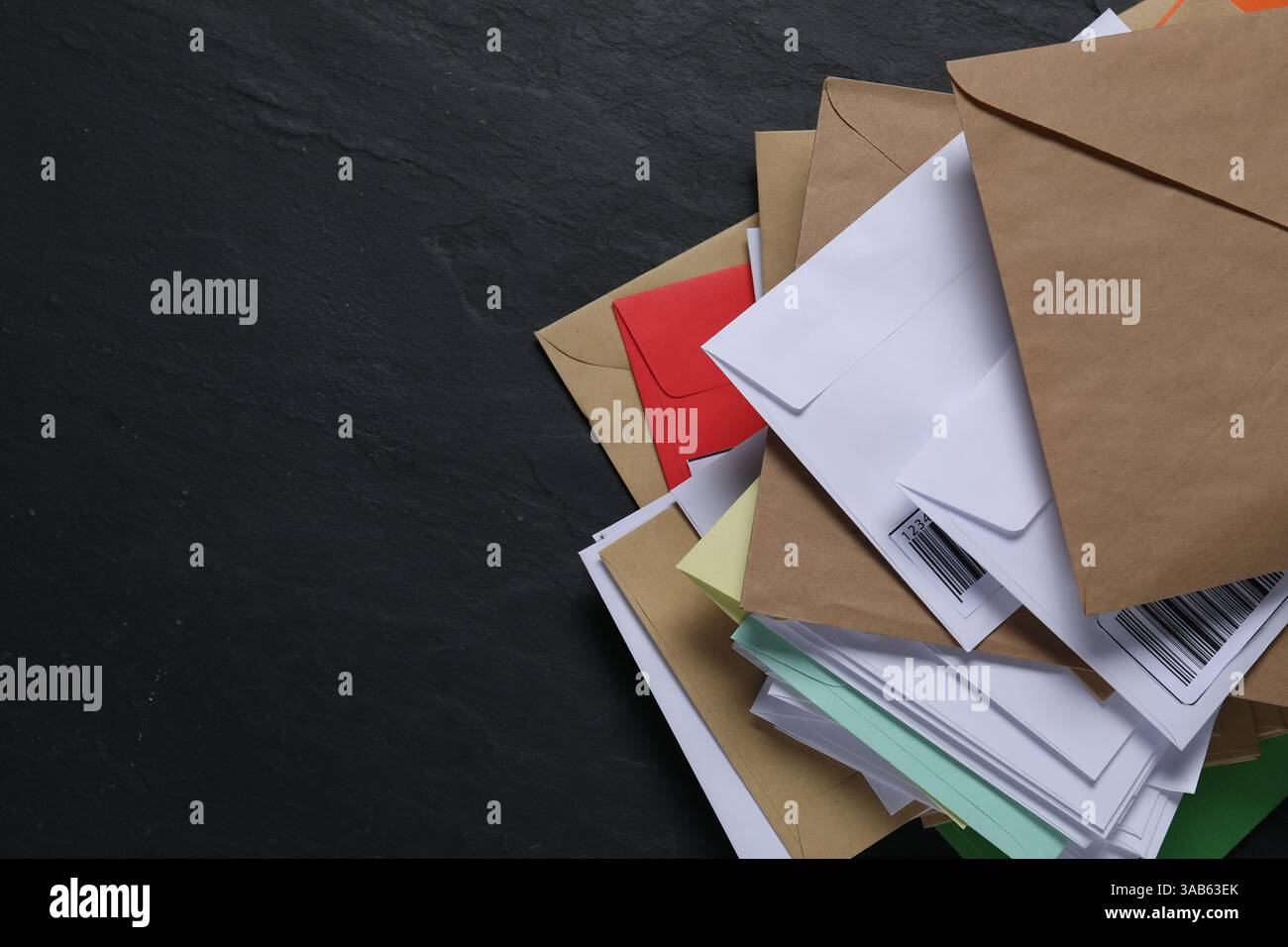 Post office. Stack of different paper envelopes on black table, top ...