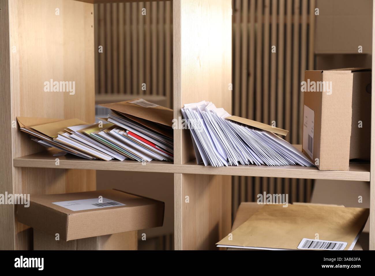 Different paper envelopes and parcels on wooden shelves in post office ...