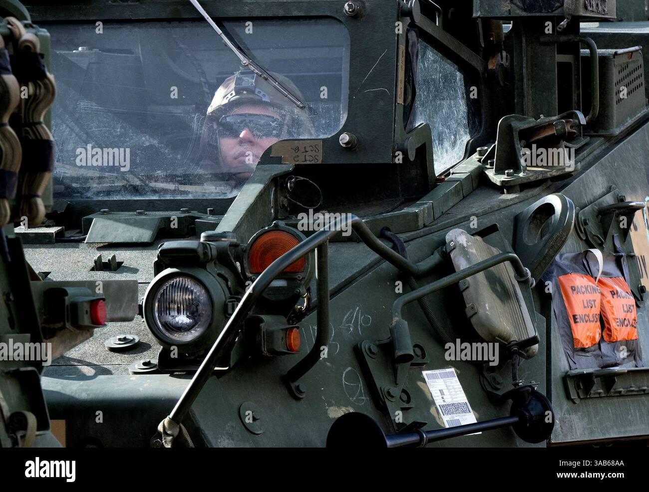 A soldier waits to drive his Stryker onto a train car in the railyard ...