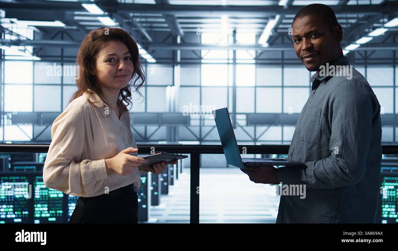 Portrait Of Happy System Administrators In Data Center Using Devices Verifying Firewall