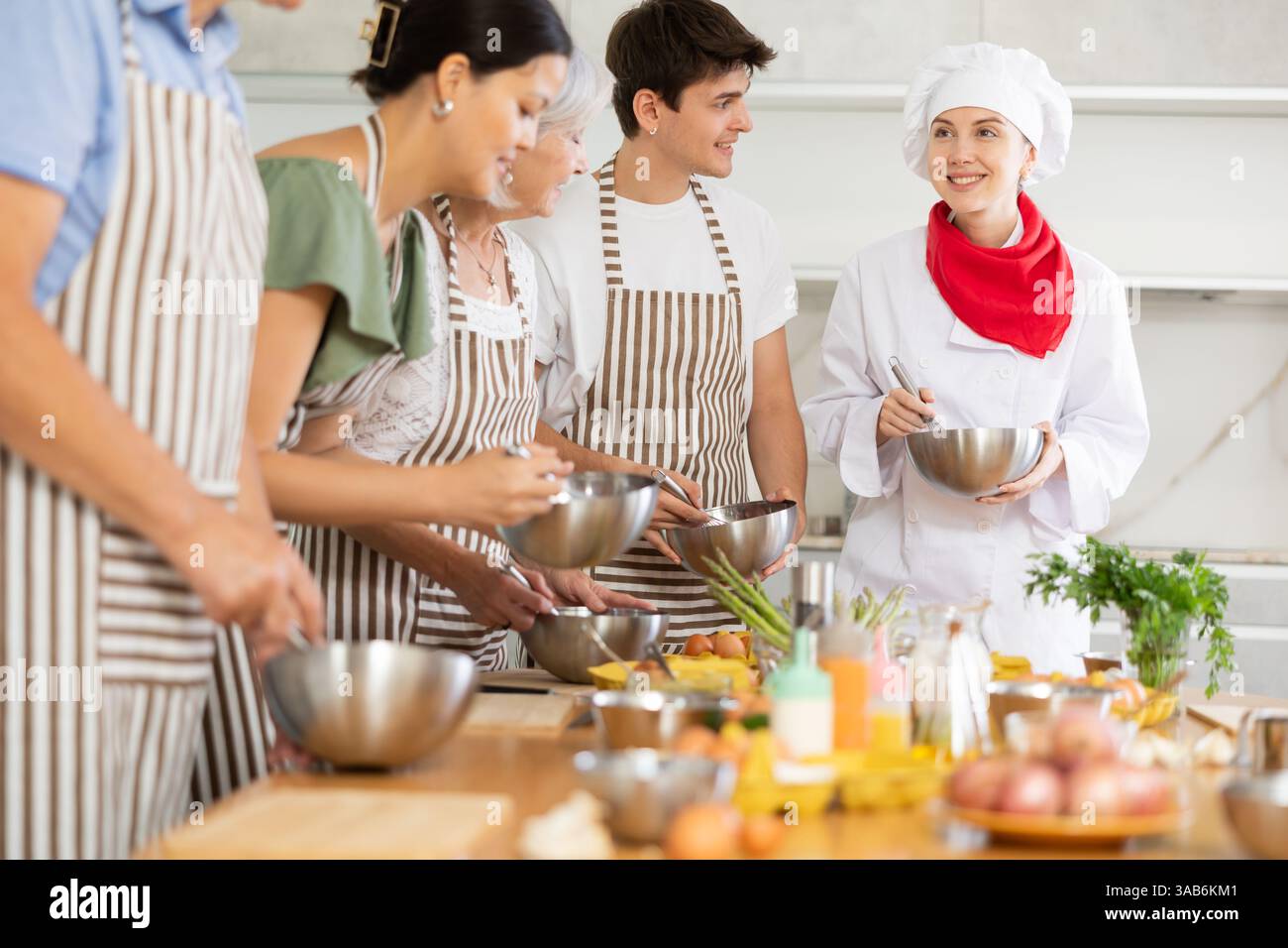 Young female cook teaches to cook group of people Stock Photo - Alamy