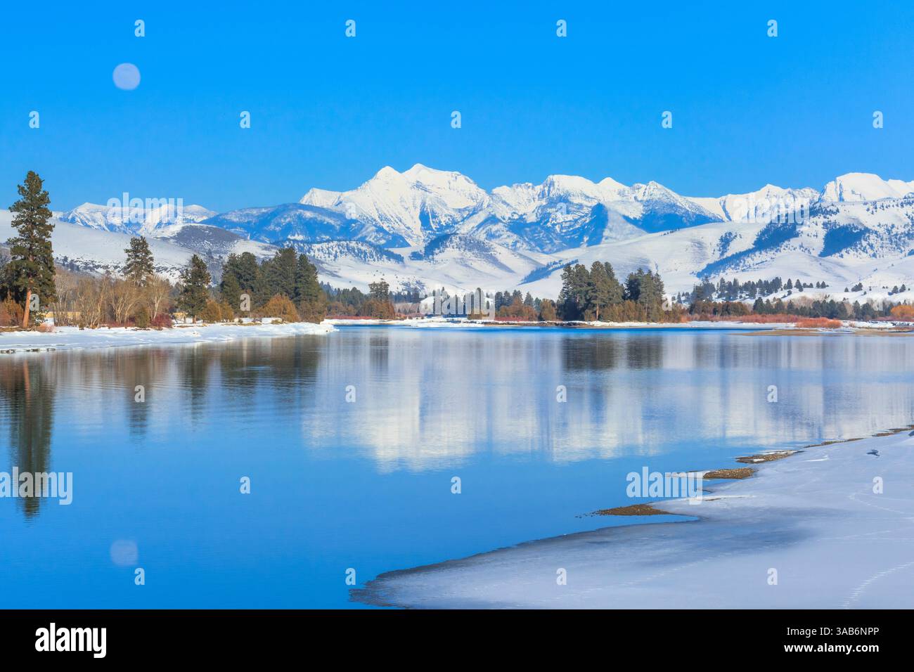 moon rising over the flathead river and mission mountains in winter ...