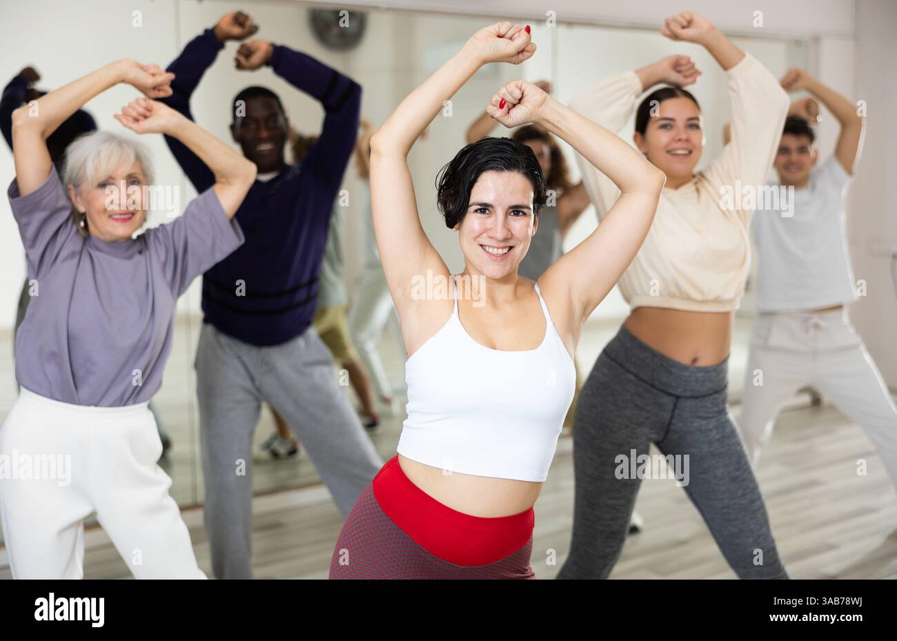 Adult group of people learn the movements of zumba Stock Photo - Alamy
