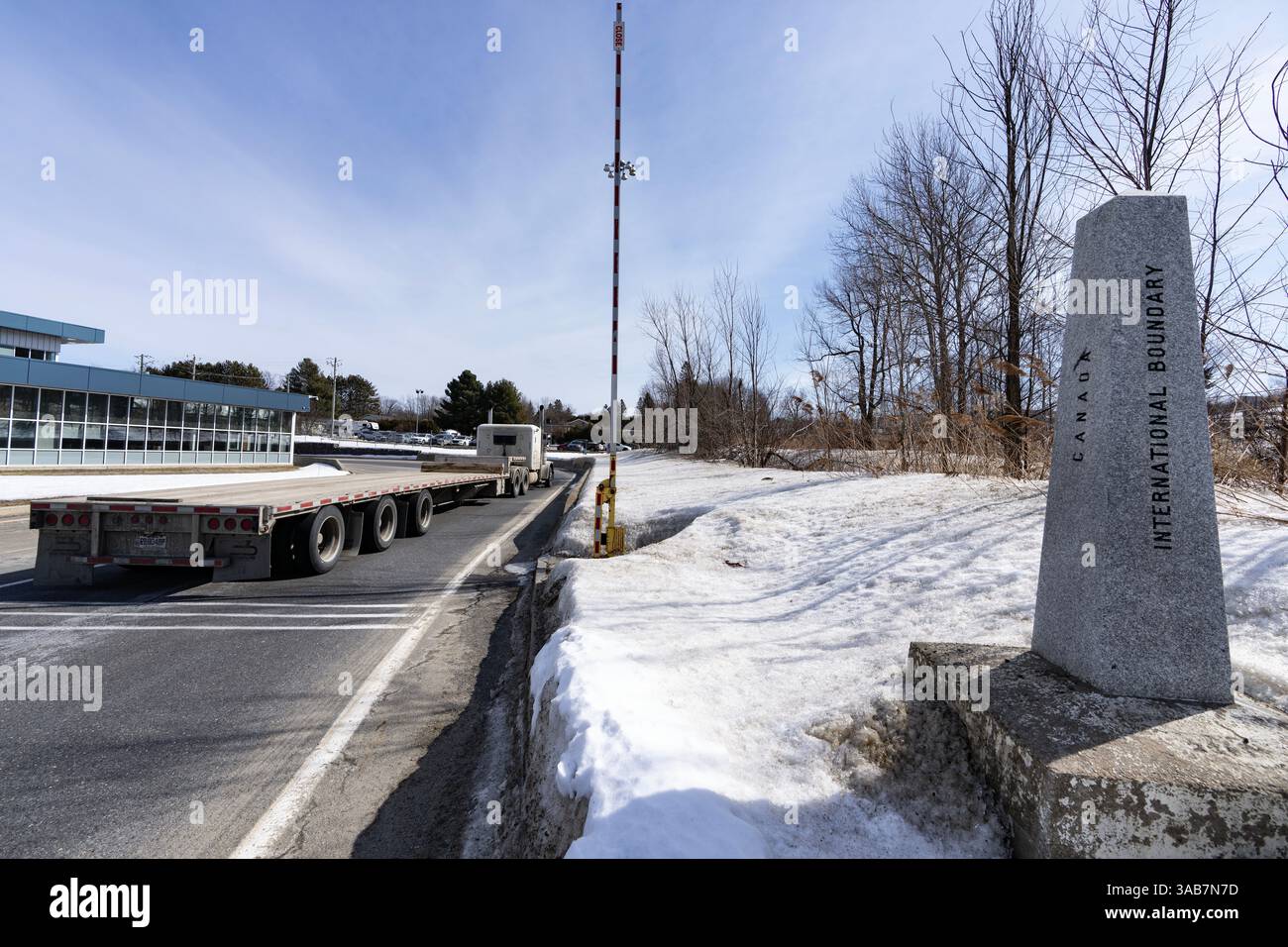Stanstead, Canada. 13th Mar, 2025. A truck passes the border marker ...