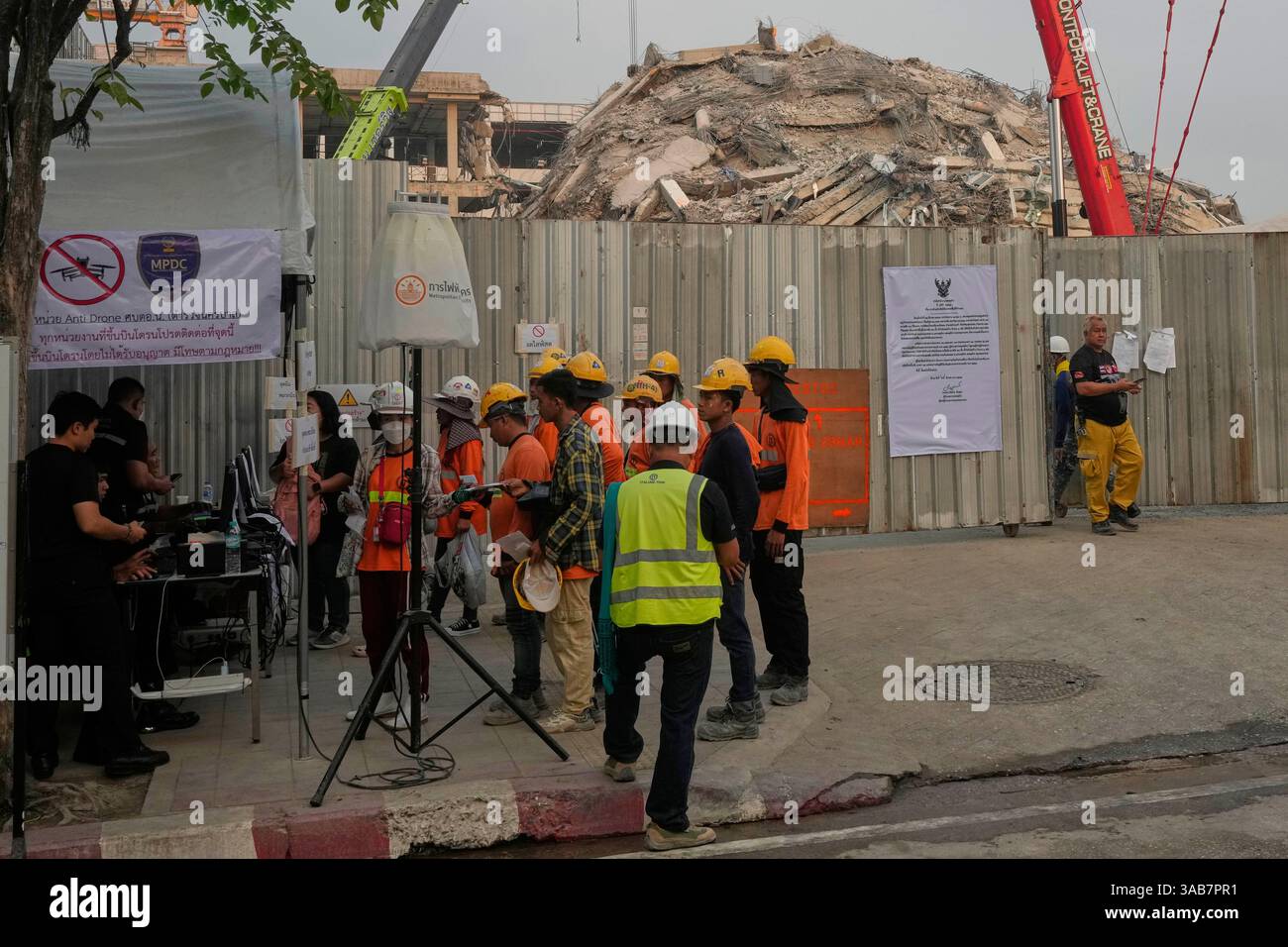 Workers get their identification checked before entering into the site ...