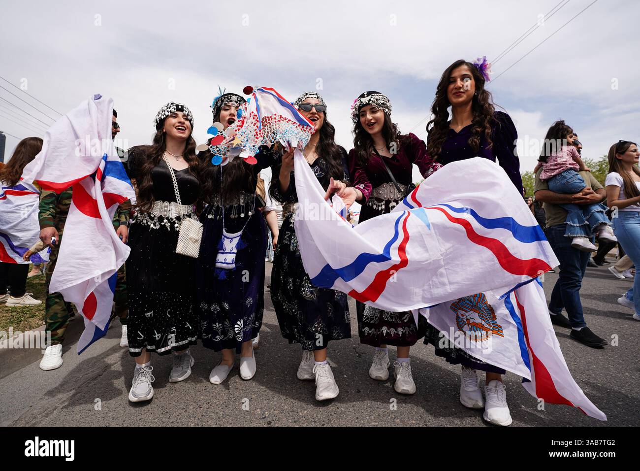 Assyrians dressed in traditional clothes march to the tunes of a ...
