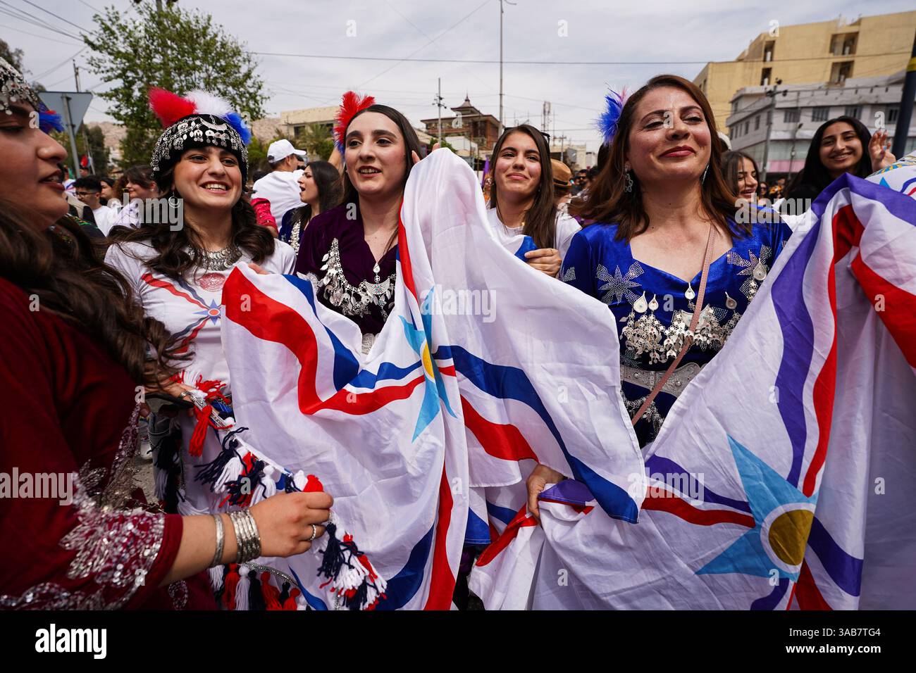 Assyrians dressed in traditional clothes march to the tunes of a ...