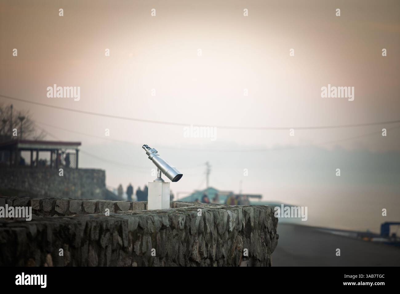 Public telescope on a stone observation platform overlooking the misty ...