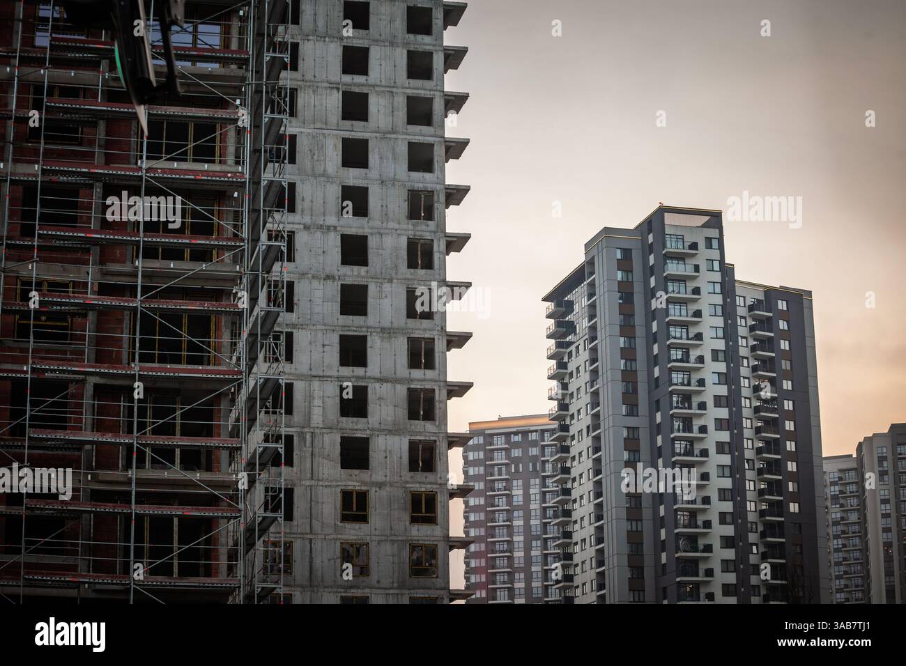 Construction site showing high-rise residential buildings with concrete structures, scaffolding ...