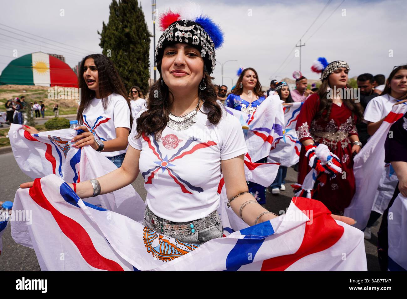 Assyrians dressed in traditional clothes march to the tunes of a ...