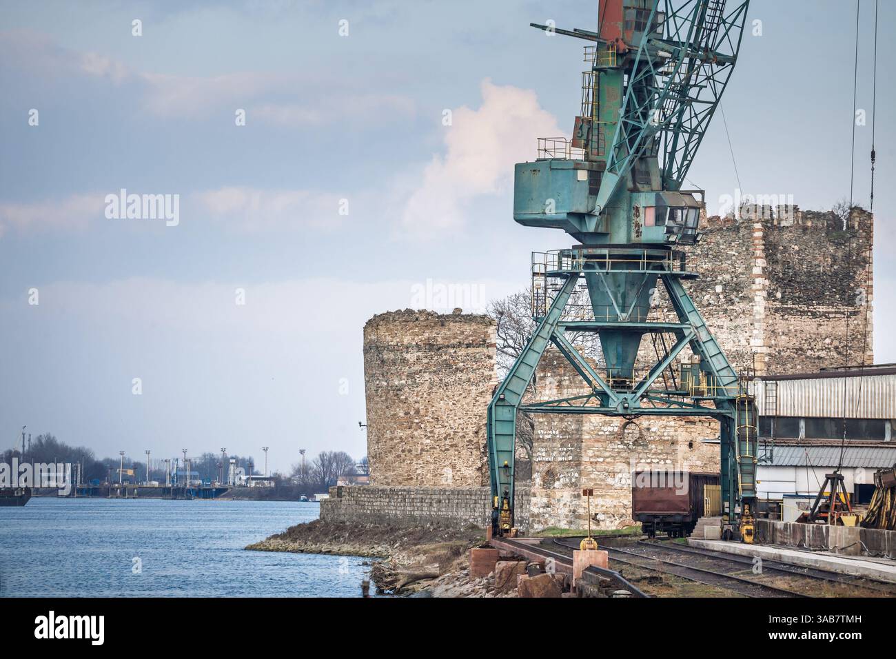 Industrial crane offloading cargo along the Danube river port in ...