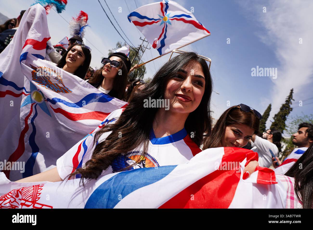 Assyrians dressed in traditional clothes march to the tunes of a ...