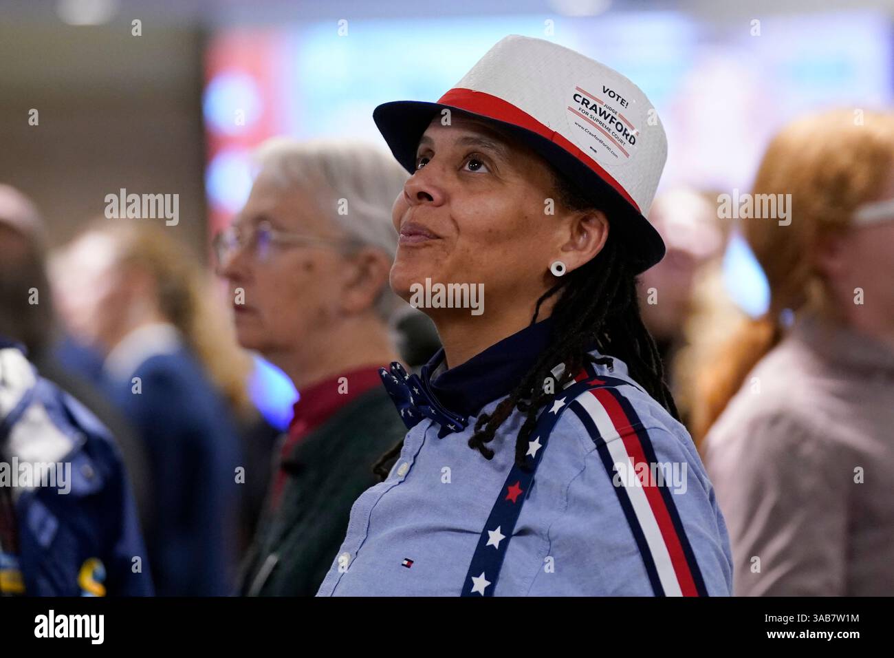 Sandy Solo, of Milwaukee, watches a broadcast as ballots are tallied ...