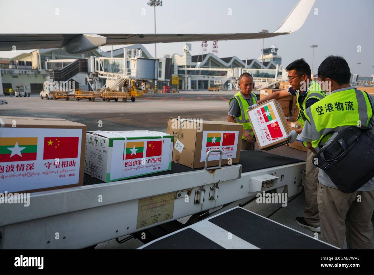 Dehong, China's Yunnan Province. 1st Apr, 2025. Staff members load ...