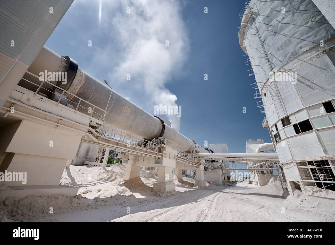 Long rotary furnace for limestone against smoking chimney Stock Photo ...