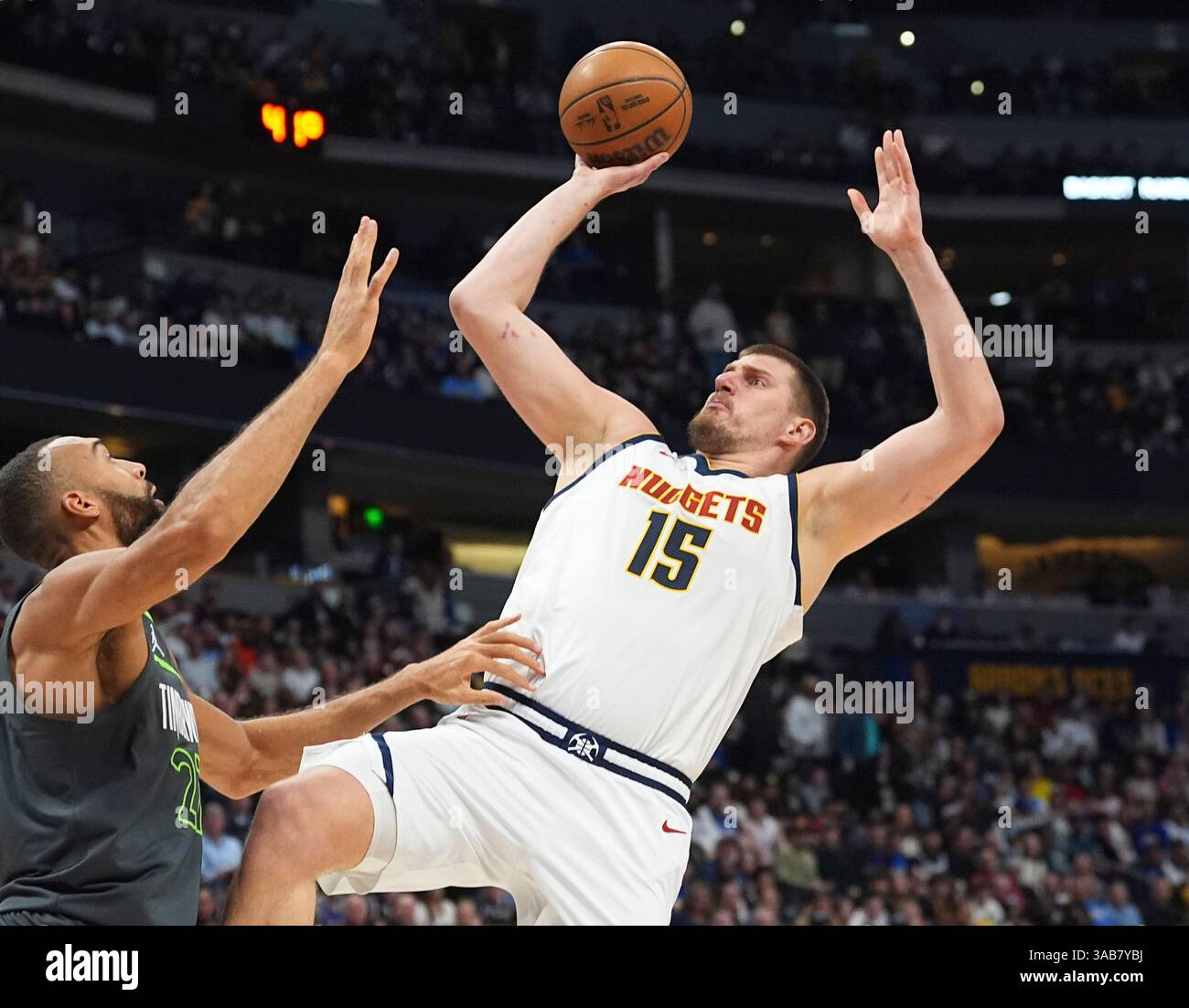 Denver Nuggets center Nikola Jokic, right, shoots for a basket over Minnesota Timberwolves ...
