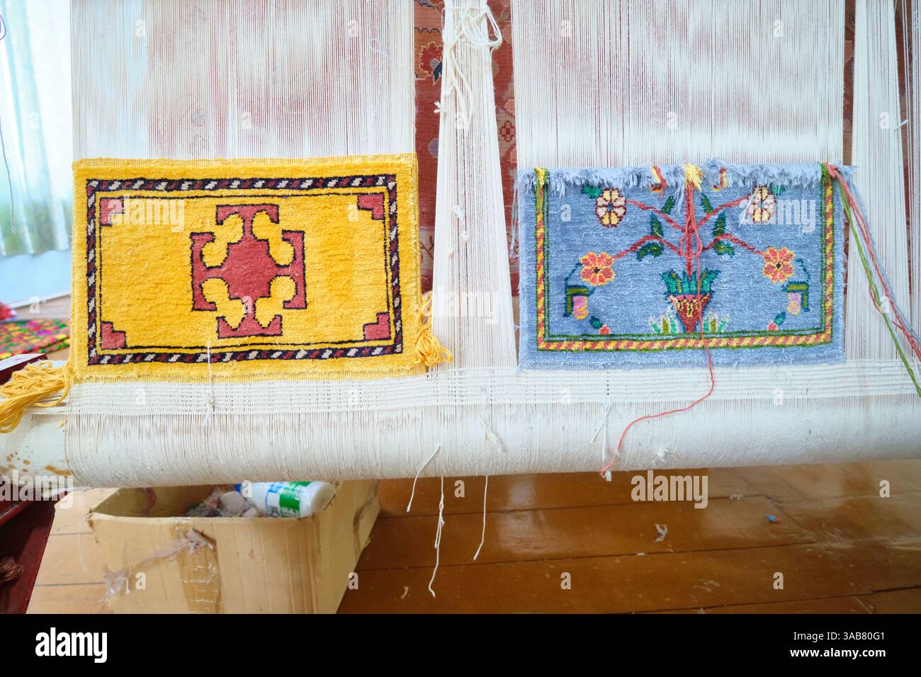 Two small, traditional rugs on a weaving loom. At the Samarkand Bukhara ...