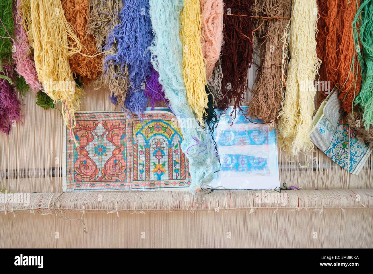 Thread color samples and a weaving patter on a traditional loom. At the ...