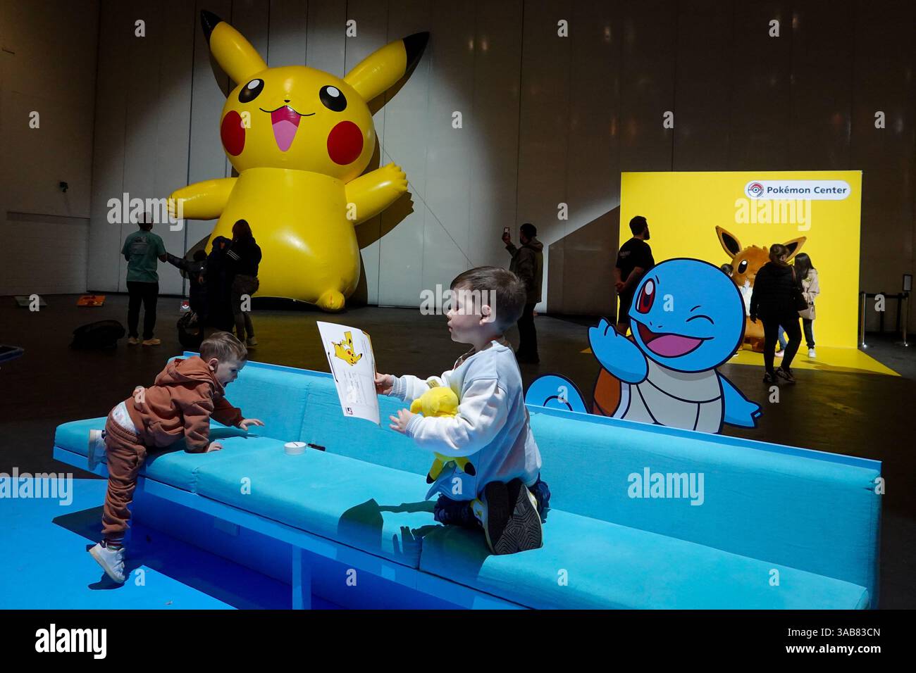Visitors are seen gesturing in front of the Pikachu decoration. London ...