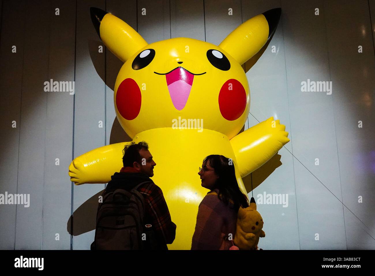 Visitors are seen gesturing in front of the Pikachu decoration. London ...