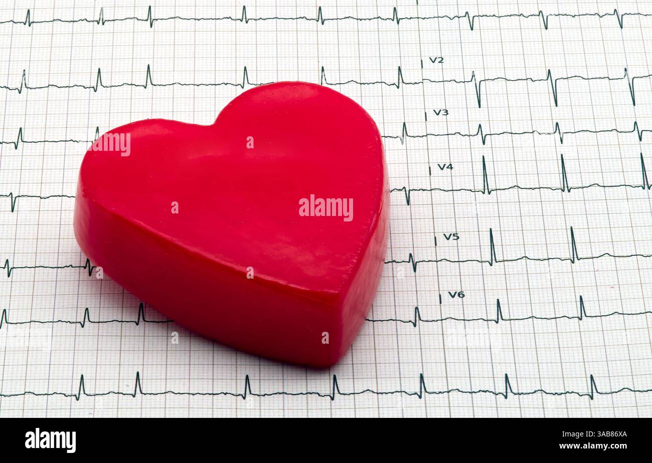 Heart-shaped object on EKG graph paper, representing health and medical ...