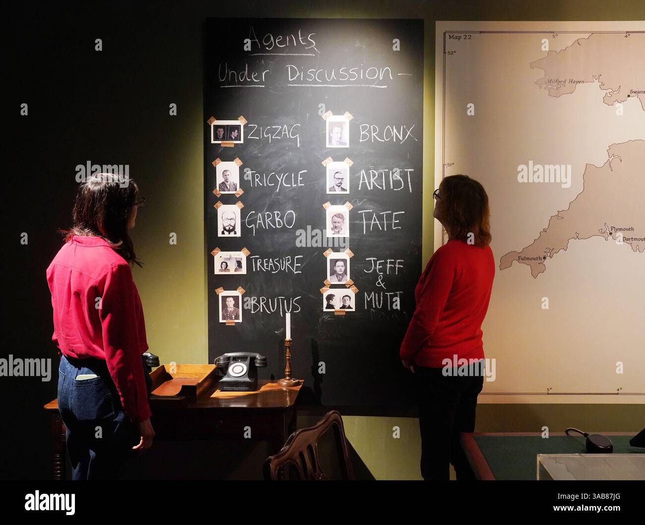 National Archives staff members look at facets of a recreation of the ...