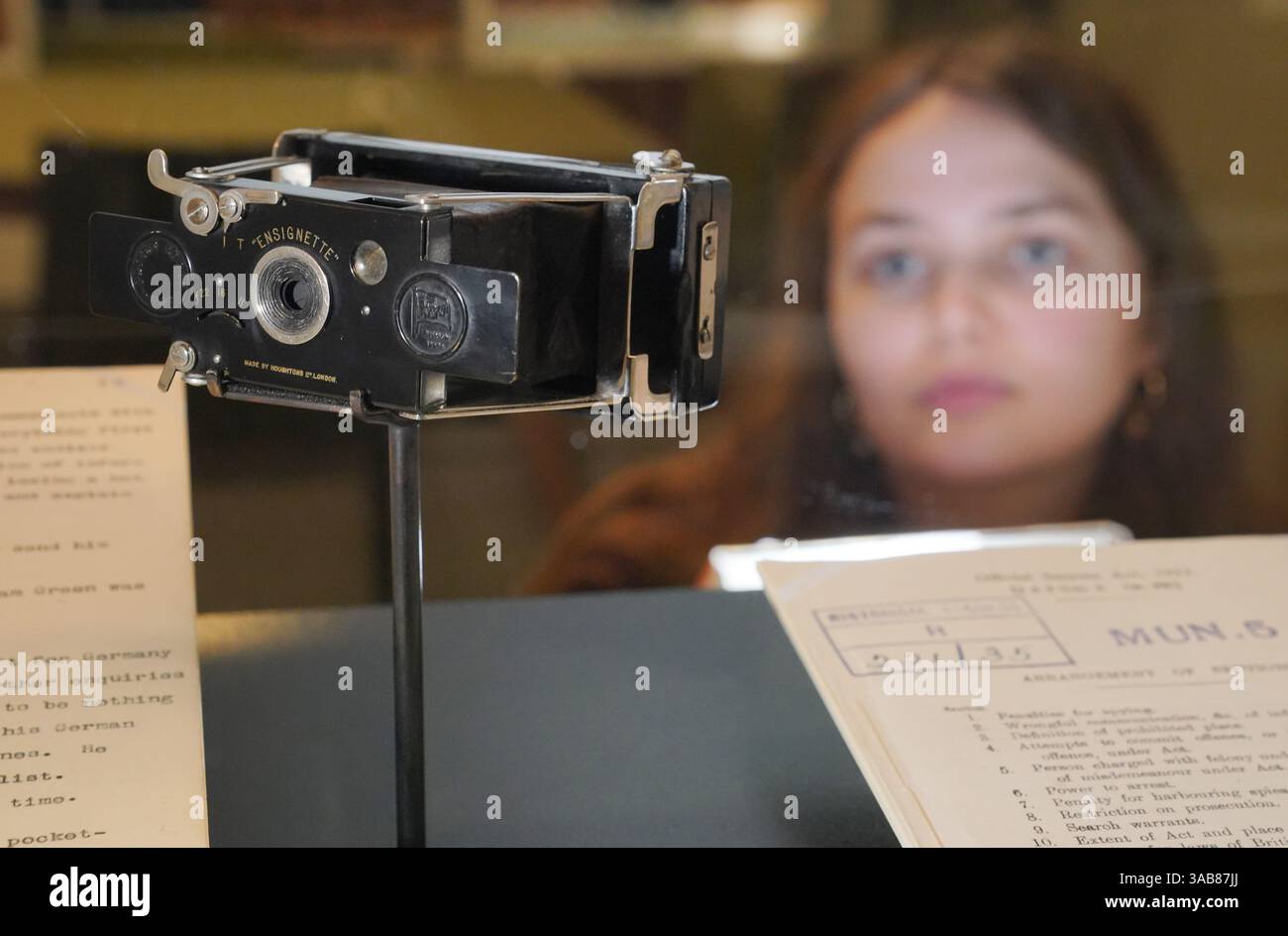 A National Archives staff member looks at a 1910 Enseignette camera ...