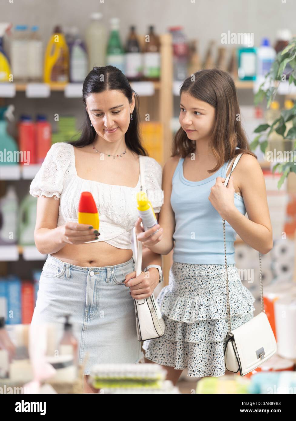 Mom with teen girl view trademark sign on label, pick eco friendly ...