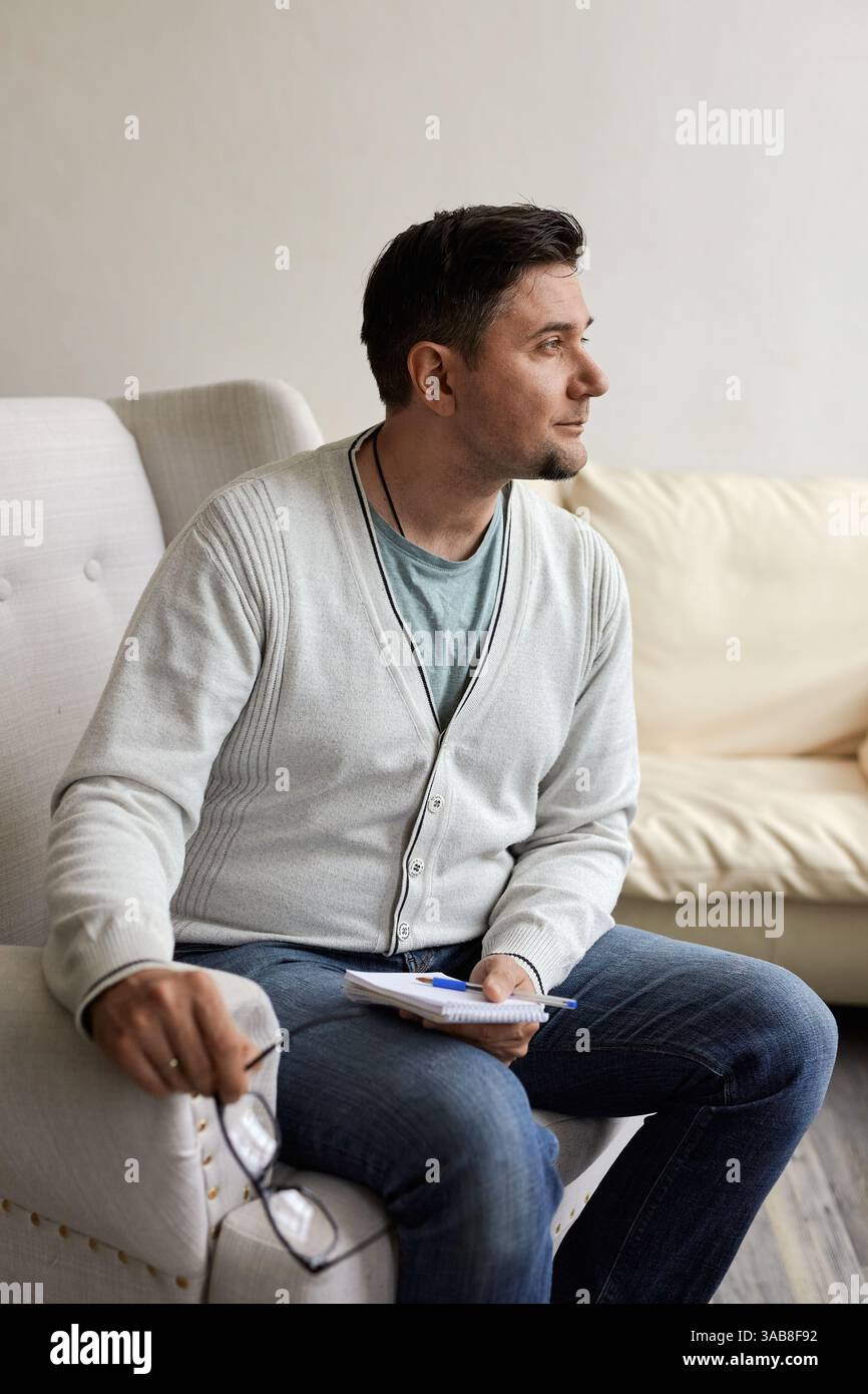 Portrait of handsome male psychologist and taking notes during therapy ...