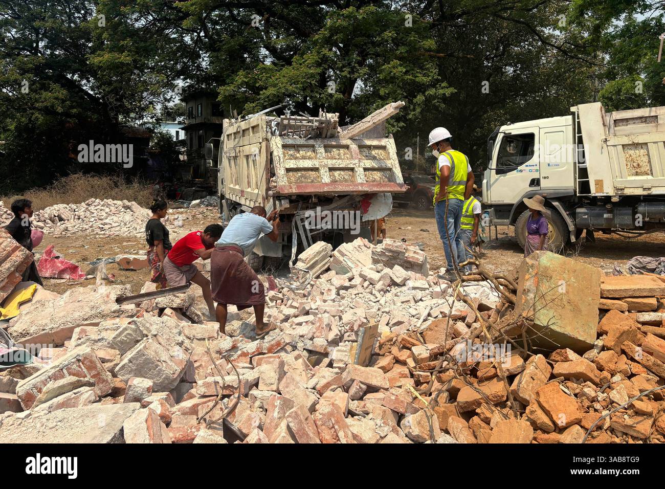 People clean debris from damaged buildings in the aftermath of Friday's ...
