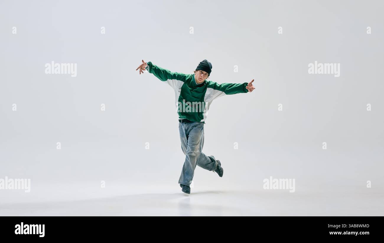 Cool attitude young guy, dancing hip-hop, spread arms wide, smoothly ...