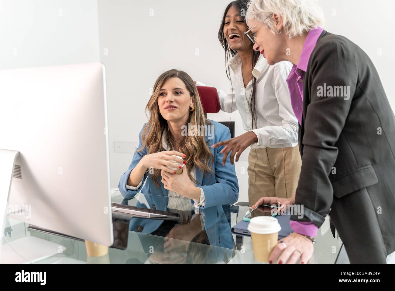 Diverse group of female professionals discussing ideas at office desk, representing ...