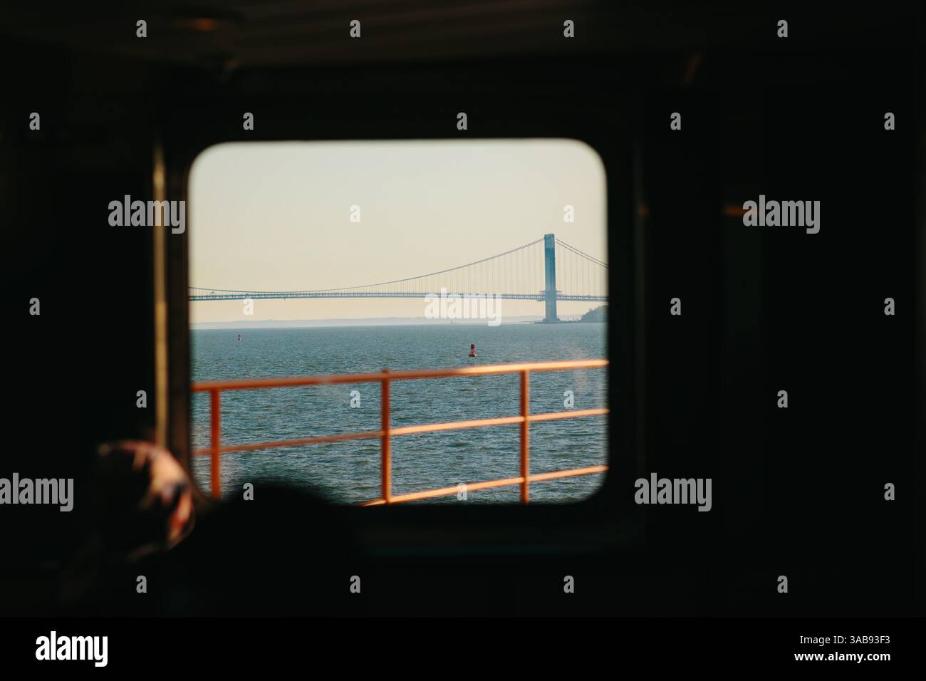 A scenic view of a suspension bridge captured through a ferry window in ...