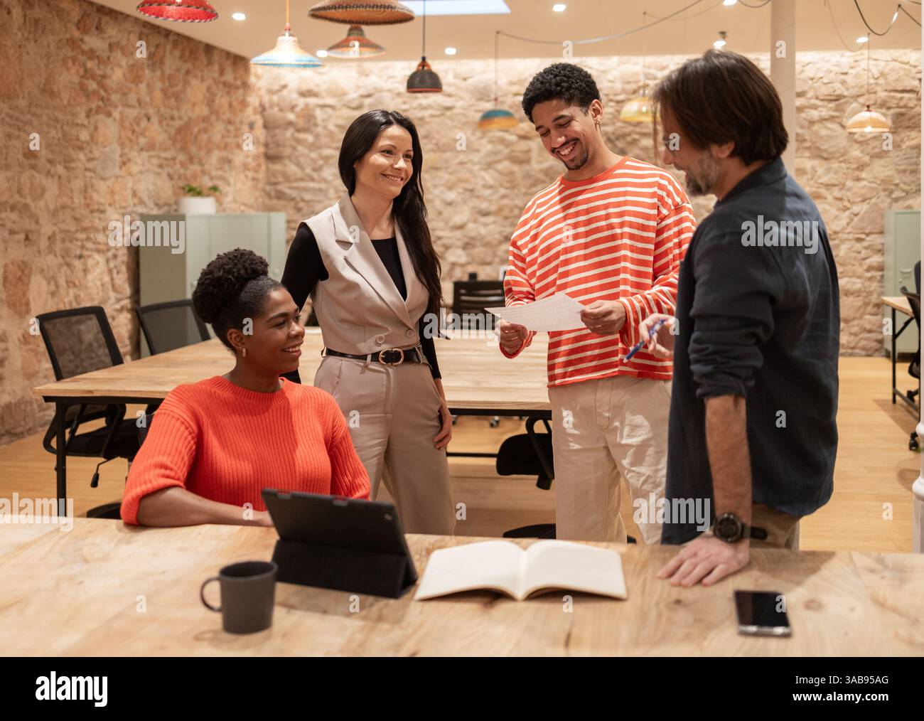 A diverse group engages in a lively discussion in a brightly lit ...