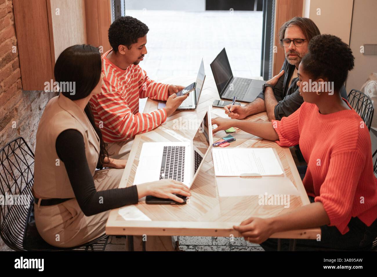 A group of diverse professionals collaborate in a modern coworking ...