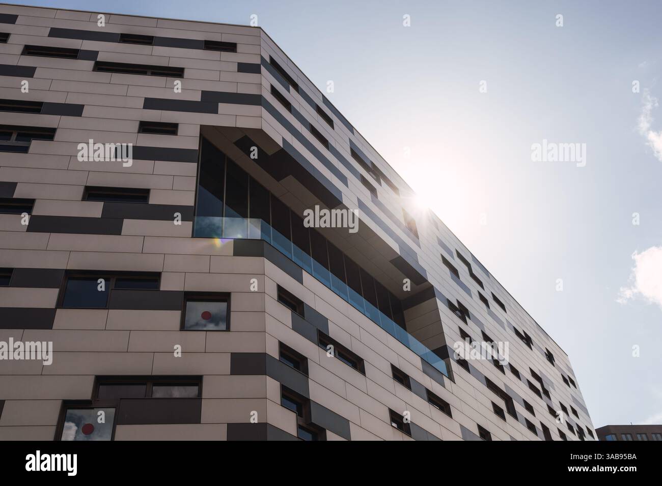 A modern building with geometric patterns, highlighted by sunlight. The ...