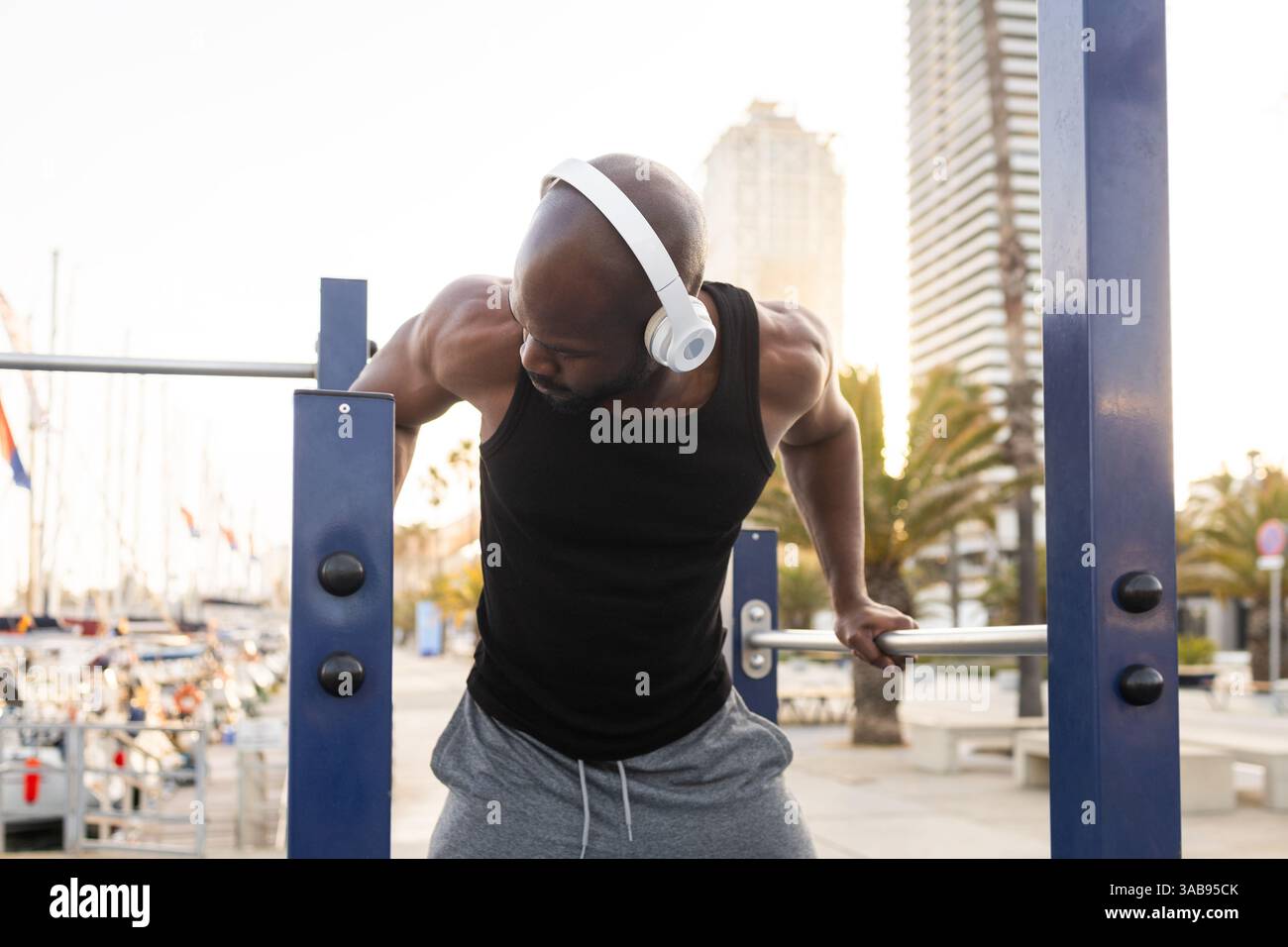 A cuban man exercises at an outdoor fitness station wearing headphones ...