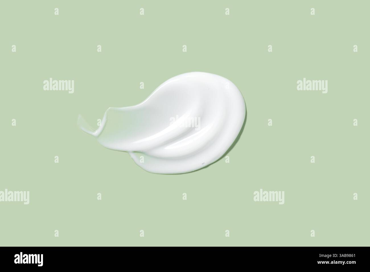 White cream smear elegantly presented on a mint green background ...