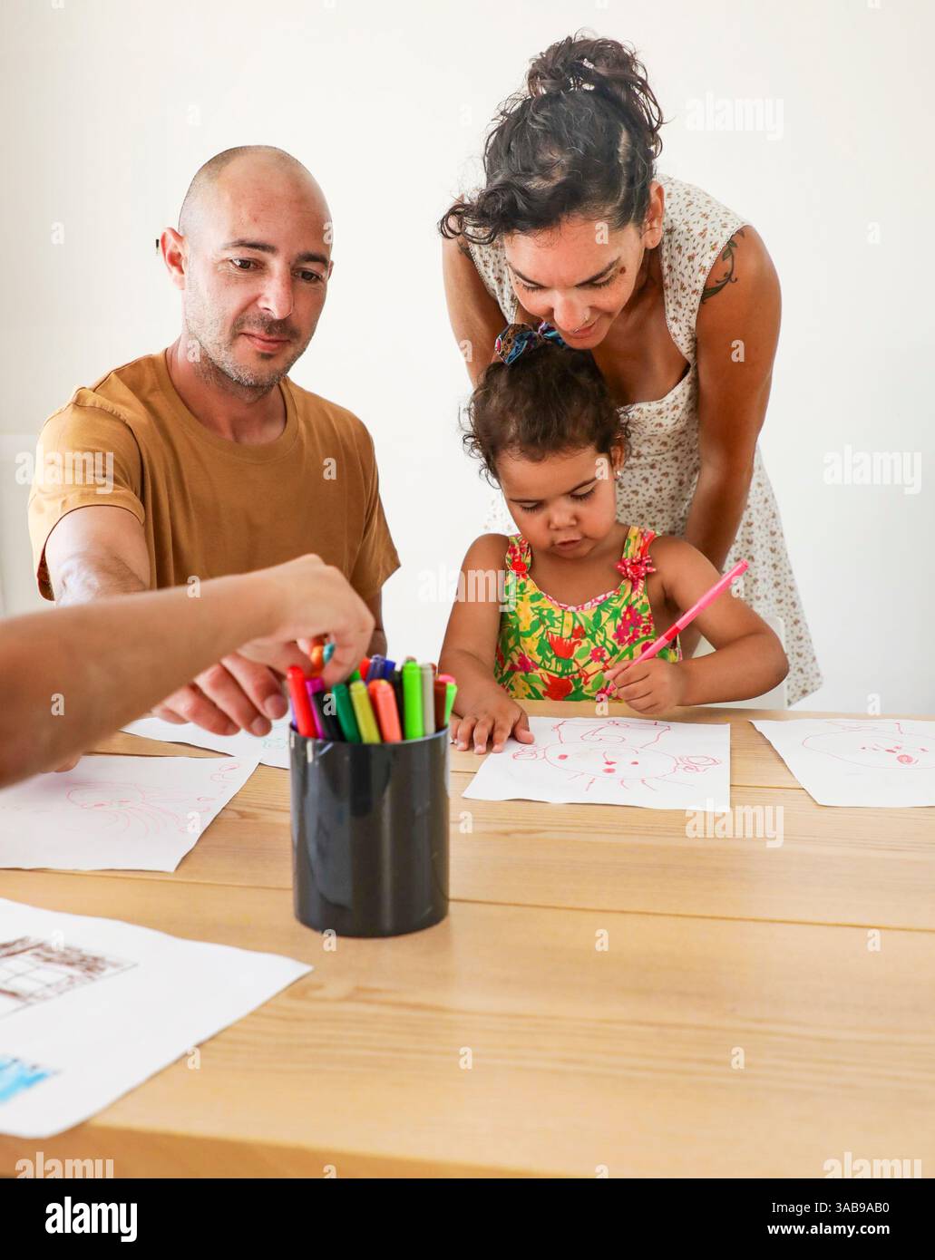 A family spends quality time drawing together at the table ...