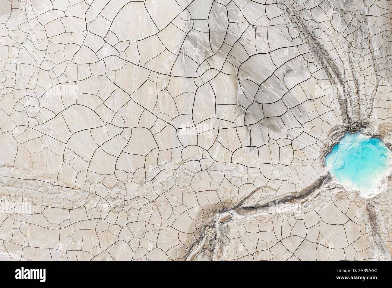 Aerial view of cracked earth with intricate lines and a vibrant blue ...