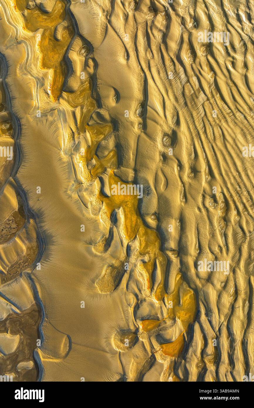Aerial view of wind sculpted patterns in golden sandy terrain. Natural ...