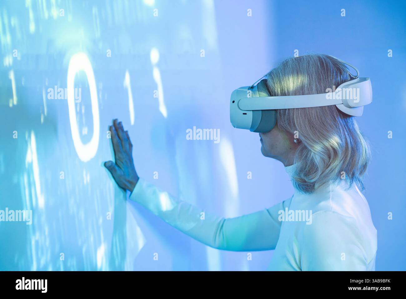 An elderly Asian woman interacts with the virtual world wearing a VR ...